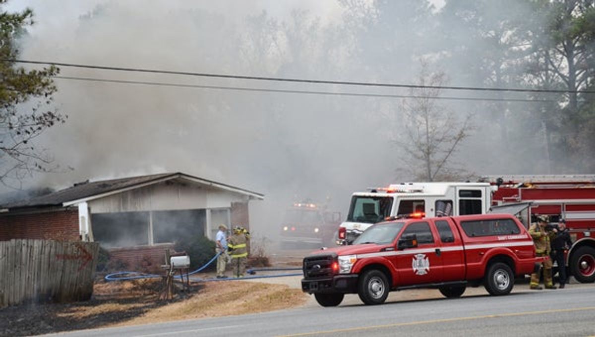 Roadside fire spreads quickly, threatens nearby home