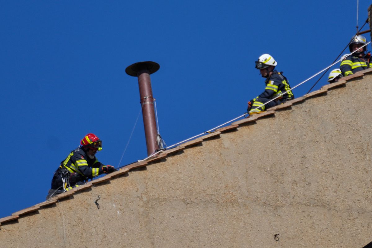 Vatican firefighters install a chimney on the roof of the Sistine Chap...