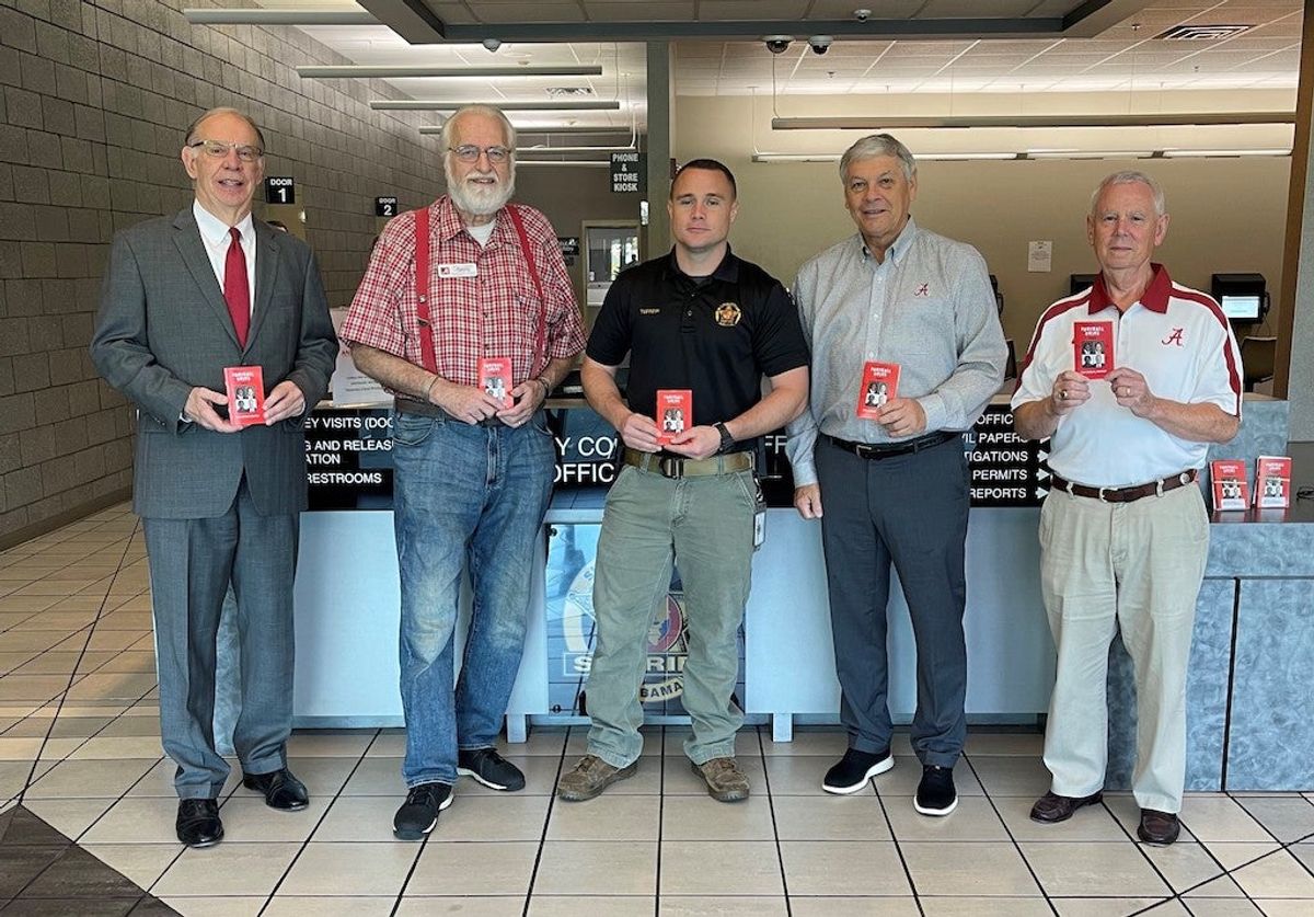 UA alumni chapter donates football guides to sheriff's offic...