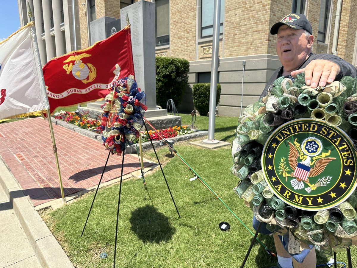 Commander Philip Greenway prepares flags for Memorial Day se...
