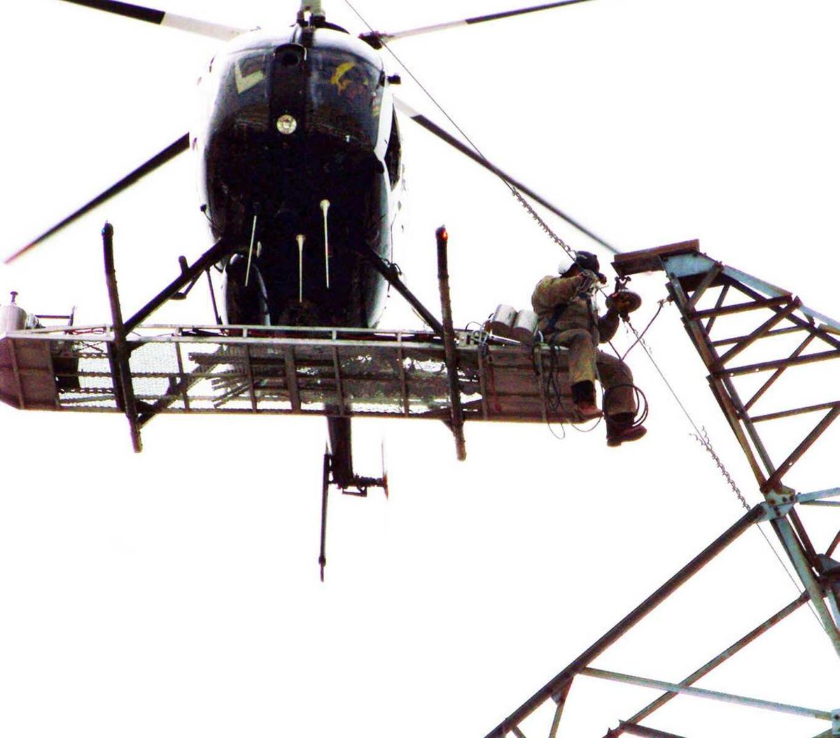 Utility lineman works from helicopter