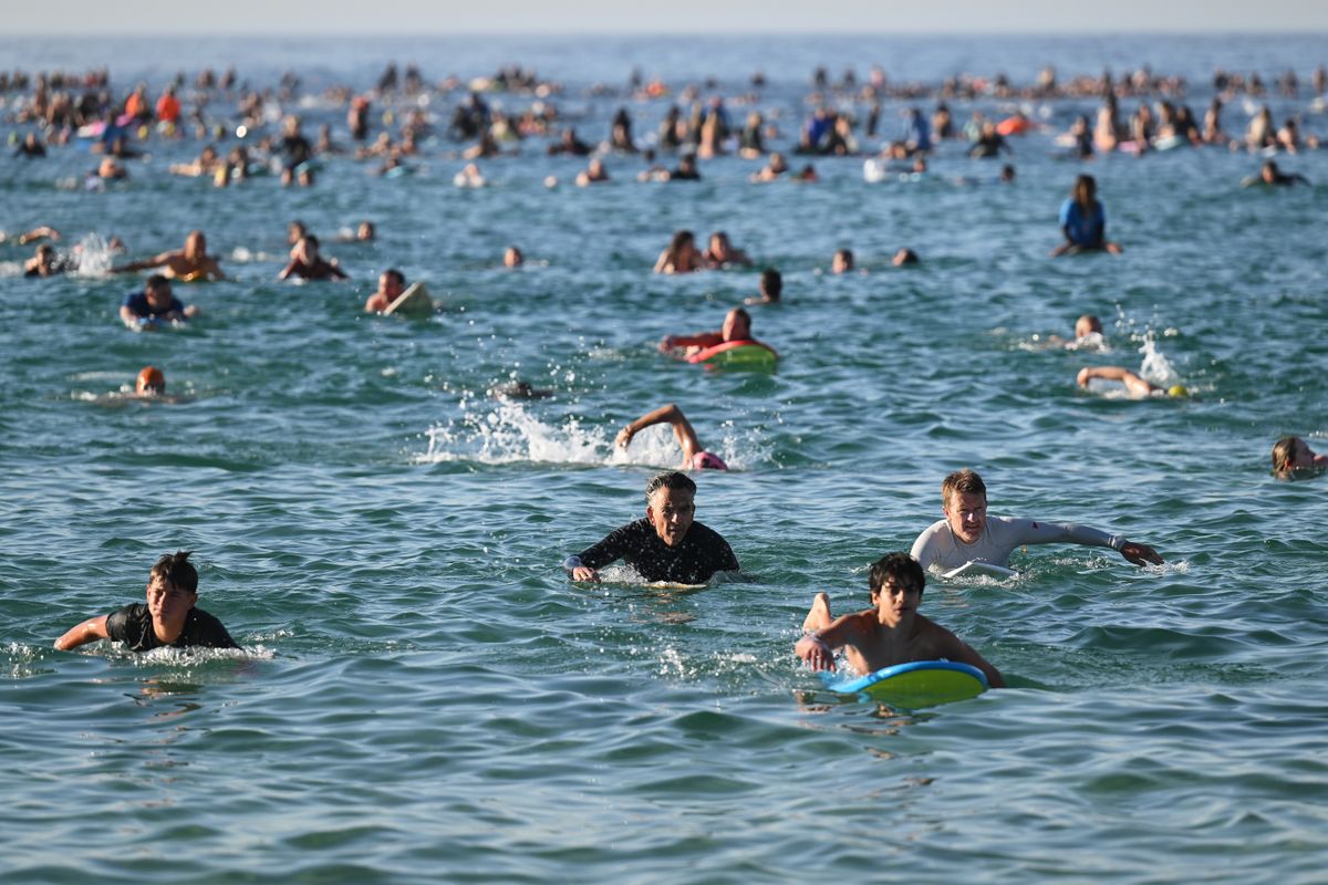 A sunrise crowd gathers at Bondi Beach in solace and defianc...